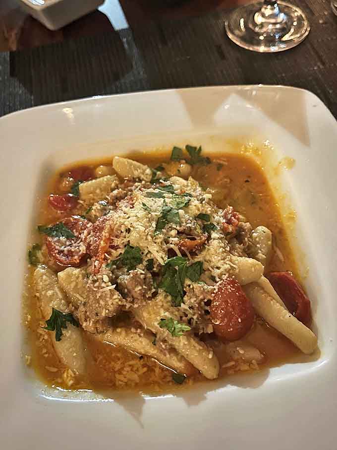 Pasta swimming in a tomato bath so rich it could buy the restaurant, garnished with enough herbs to start a small garden.