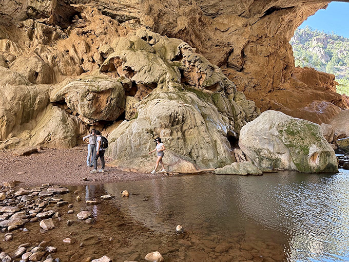 Adventurers explore the cavern's cool embrace, dwarfed by limestone walls that have witnessed the passing of civilizations with geological indifference.