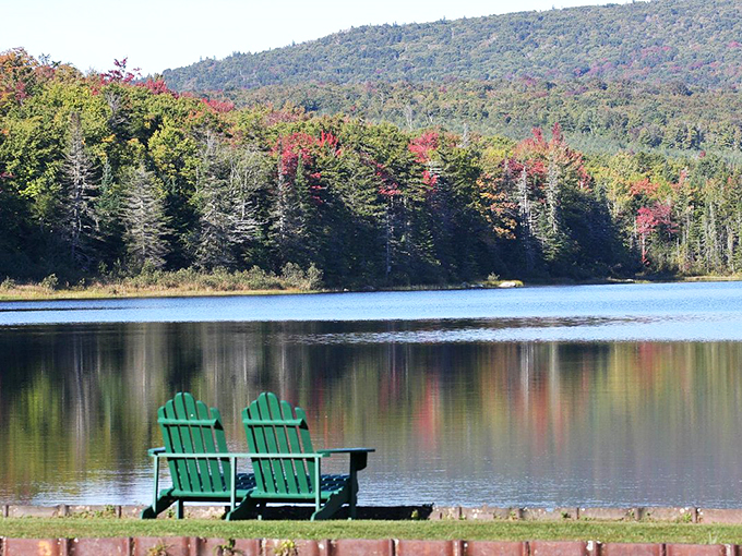 Fall colors reflect in crystal waters while Adirondack chairs patiently wait for someone to pause and appreciate.