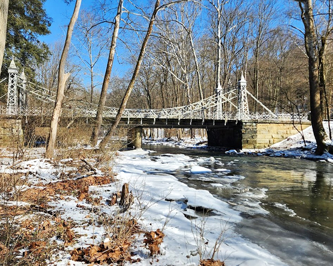 Seasons change, beauty remains: Even in late fall, the bridge maintains its elegant presence as leaves drift into the creek below.