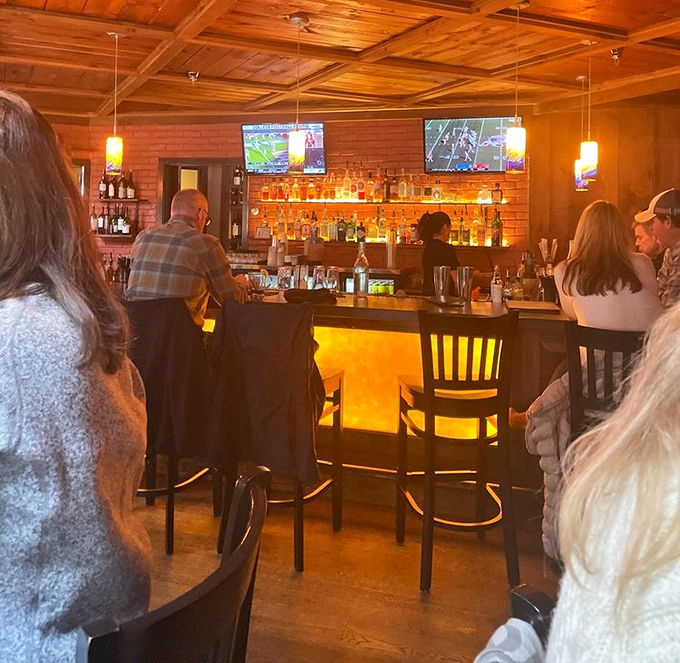 The bar glows with amber warmth, bottles backlit like treasures, inviting patrons to settle in for carefully crafted cocktails and conversation.