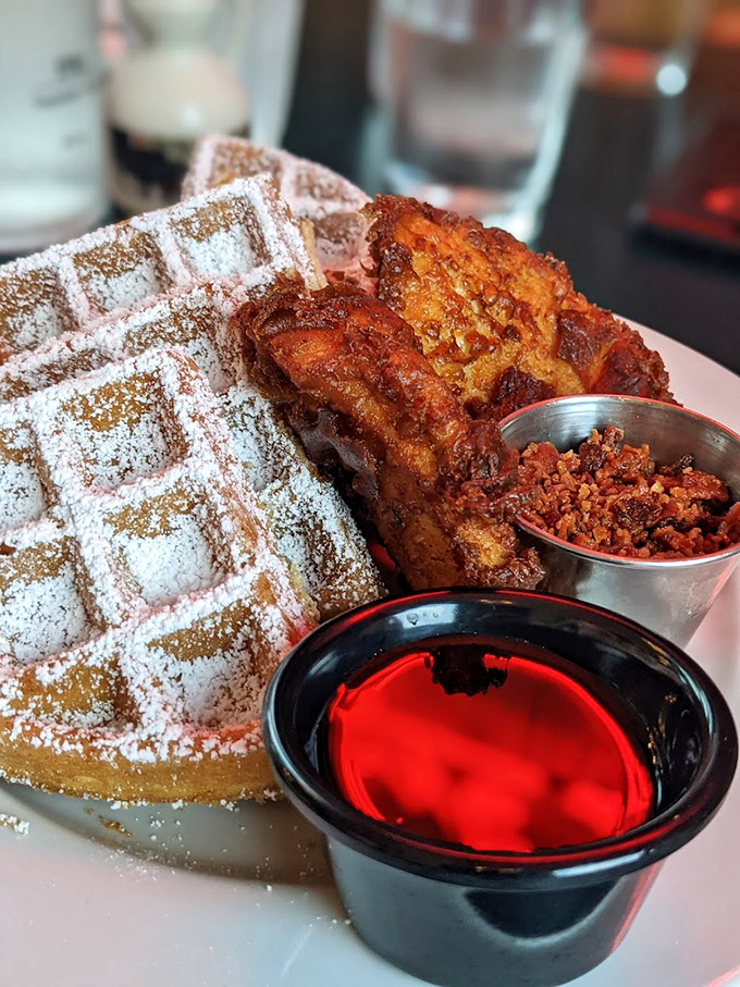 Sweet meets savory in perfect harmony &ndash; golden waffles cradle crispy chicken while powdered sugar and spiced crumble take this classic to new heights.