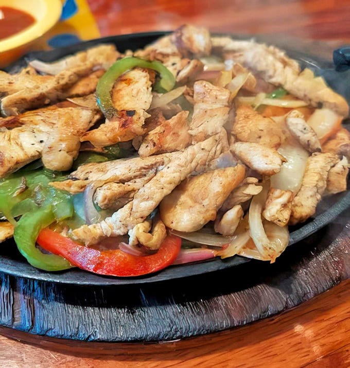 Chicken fajitas: Sizzling drama on a cast iron skillet &ndash; tender chicken strips mingling with caramelized peppers and onions in a steamy flavor tango.
