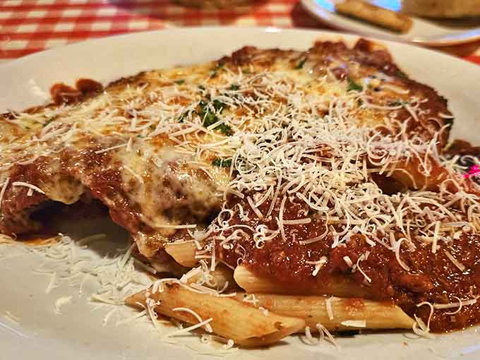 Chicken Parmigiana done right &ndash; golden-crisp exterior giving way to tender meat, all embraced by tangy sauce and melty cheese atop al dente pasta.
