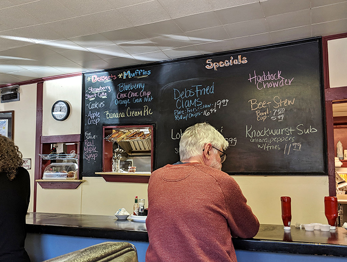 The specials board showcases seasonal inspirations, while a patron contemplates life's big questions &ndash; like whether to order more coffee.