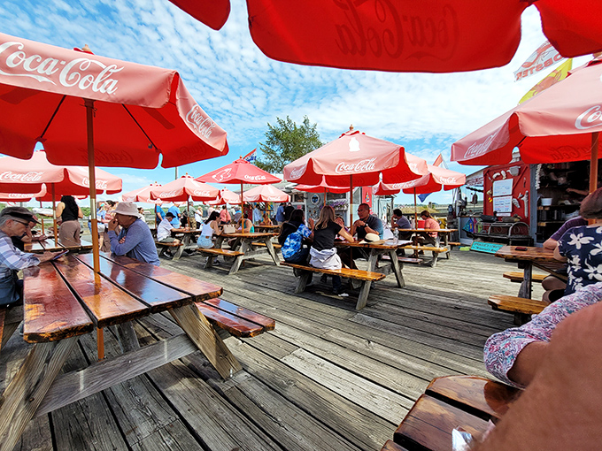 A sea of red umbrellas shelters happy diners enjoying the fruits of their patient waiting.