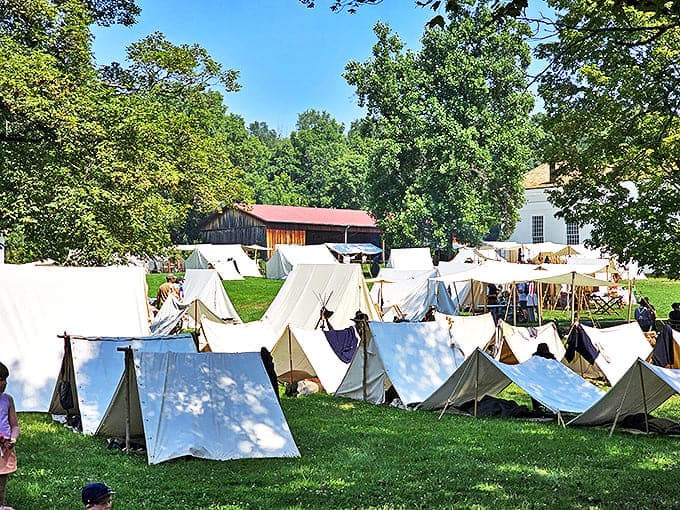 A village of white tents transforms the grounds into a living history encampment where modern visitors can experience life before Netflix and DoorDash.