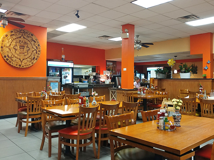 Vibrant orange walls and traditional d&eacute;cor create a festive atmosphere that complements the bold flavors coming from the kitchen.