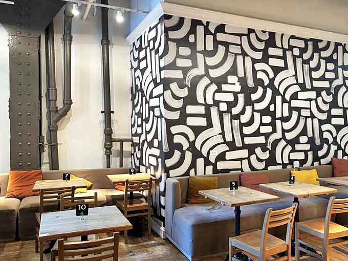 Abstract wall art creates a dramatic backdrop for coffee contemplation, proving good design and good pastry belong together.