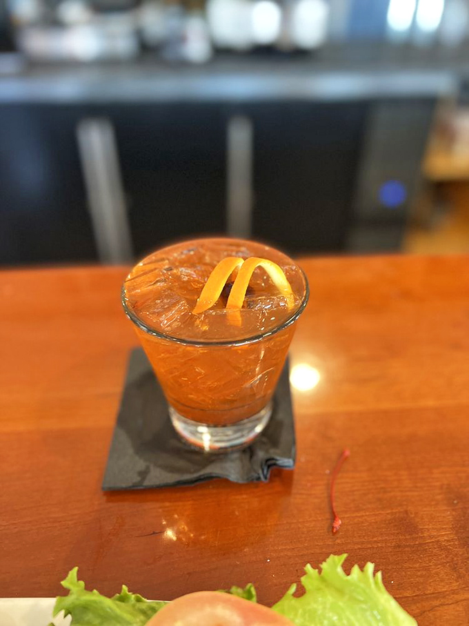 A perfectly crafted cocktail awaits with its citrus twist, the ideal companion for watching sailboats drift across the bay's shimmering surface.