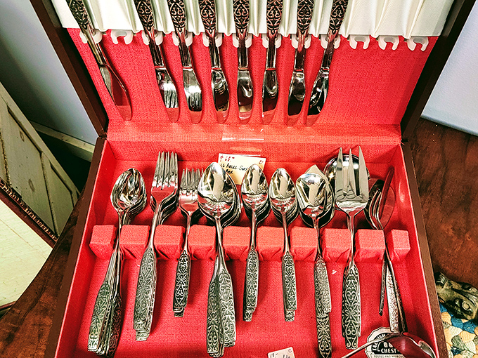 Sterling silver flatware nestles in red velvet, patterns etched into handles that have served countless special occasions.