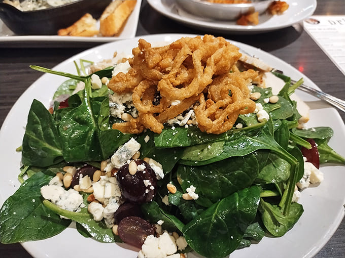 Not just any salad &ndash; a spinach masterpiece crowned with crispy fried onions and blue cheese crumbles that makes eating greens feel like cheating.