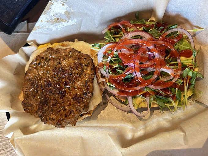 Savory perfection: this chorizo patty sandwich bursts with fresh vegetables and melty cheese, demanding a two-handed commitment.