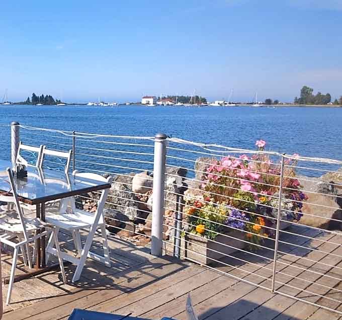 Outdoor seating where flower boxes meet harbor views, creating the kind of dining backdrop that makes every meal taste better than it already does.