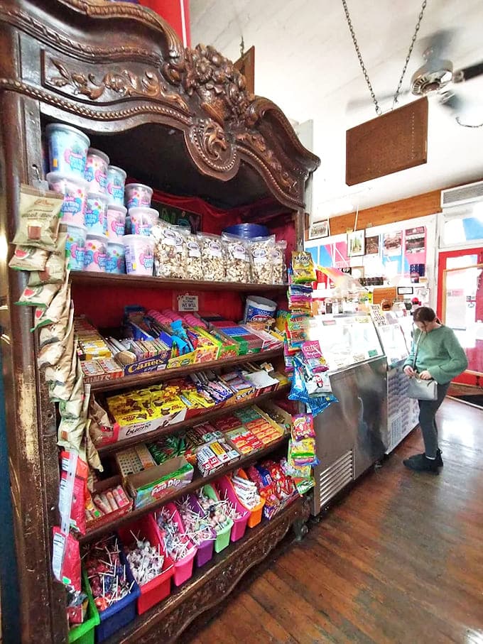 This ornate wooden cabinet, repurposed as candy display, proves everything's better when served with a side of history.