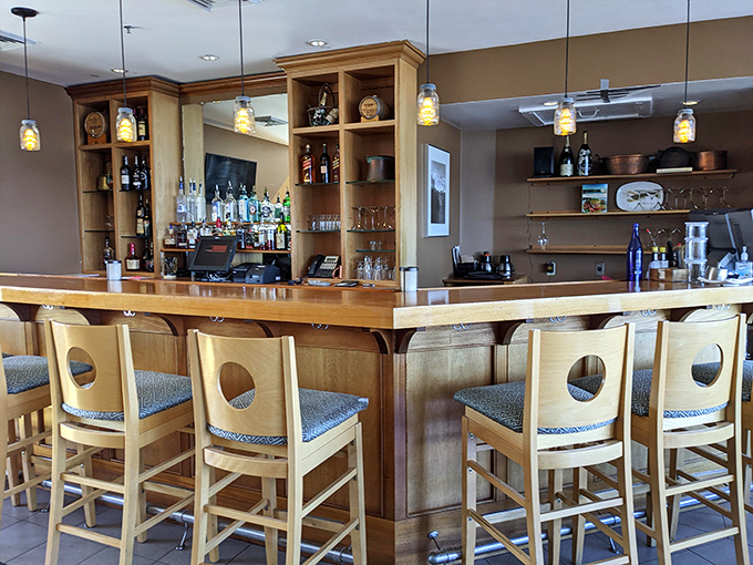 This isn't just a place to wait for your table – it's a front-row seat to mixology magic with those distinctive porthole-backed stools.