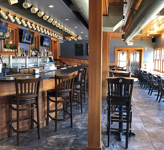 The bar area invites patrons to settle in with local craft beers and cocktails while admiring the warm wooden craftsmanship throughout.
