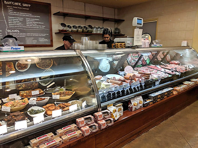 The deli case displays prepared foods, fresh meats, and imported cheeses like edible artwork waiting to be discovered.