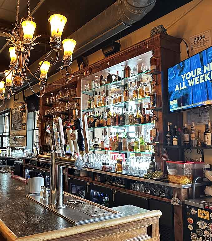 The bar area glows with amber light, bottles gleaming like treasures as bartenders craft cocktails with the precision and care of artisans.