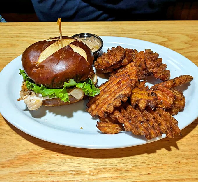 This chicken sandwich on a pretzel bun with sweet potato waffle fries isn't just lunch &ndash; it's an edible hug for your taste buds.