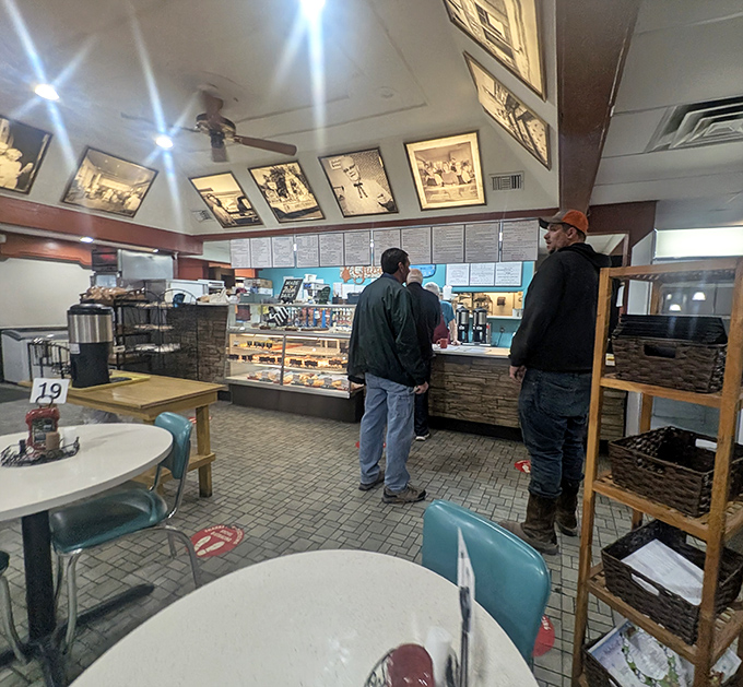 Customers contemplate their sweet destiny at the counter, where daily decisions between pie varieties constitute the day's most pleasant dilemma.