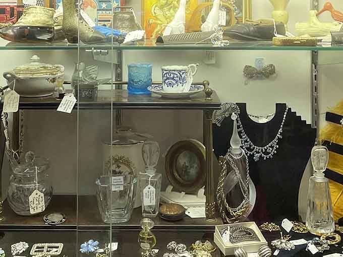 Vintage jewelry and glassware sparkle behind glass, each piece representing someone's treasured possession from an era when quality actually mattered to manufacturers.