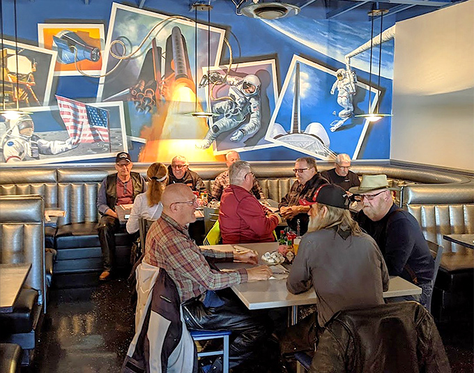 Locals and travelers alike gather under space-themed murals, sharing stories and meals in this unique desert oasis of quirky charm.