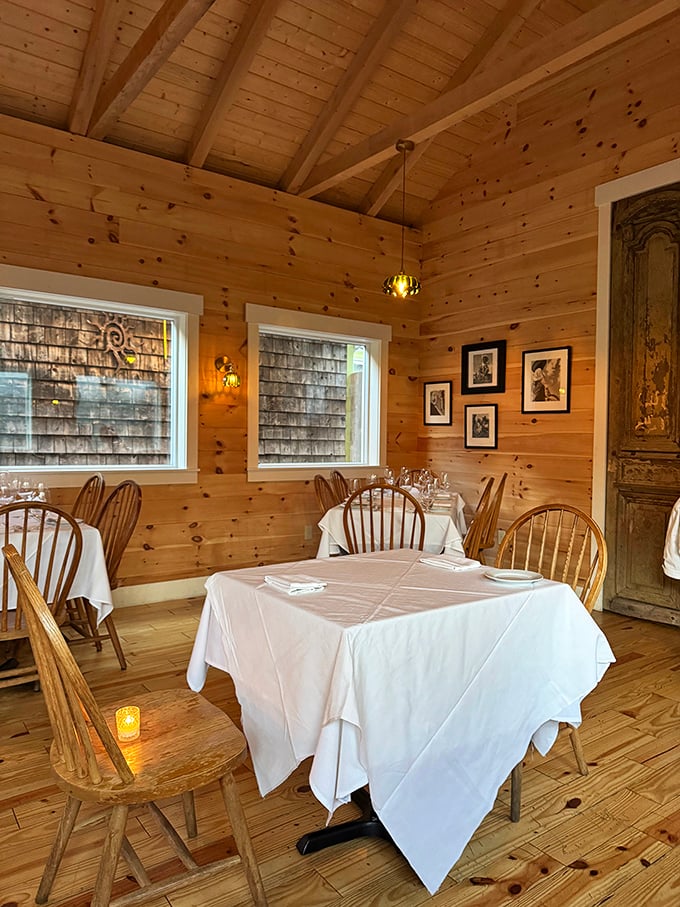 The pine-paneled dining room offers a cozy, intimate atmosphere that captures Maine's rustic charm with elegant simplicity.