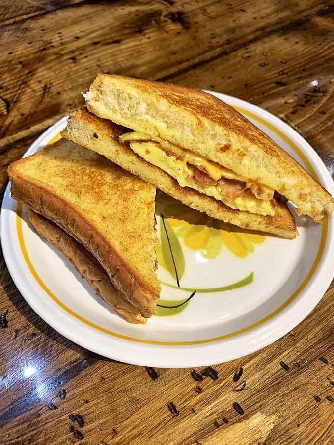 The breakfast sandwich &ndash; golden-toasted bread embracing eggs and bacon &ndash; proves that morning classics need no reinvention, just perfect execution.