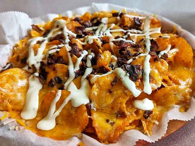 Cheese-covered chips become an edible canvas for bacon bits and ranch drizzle &ndash; proof that the best appetizers are the ones that disappear before the main course arrives.