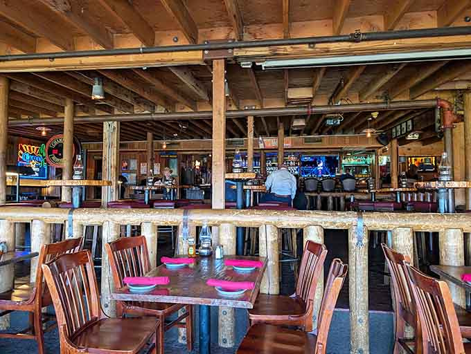 Two-story rustic dining with exposed beams and a full bar creates the ultimate Western saloon atmosphere.