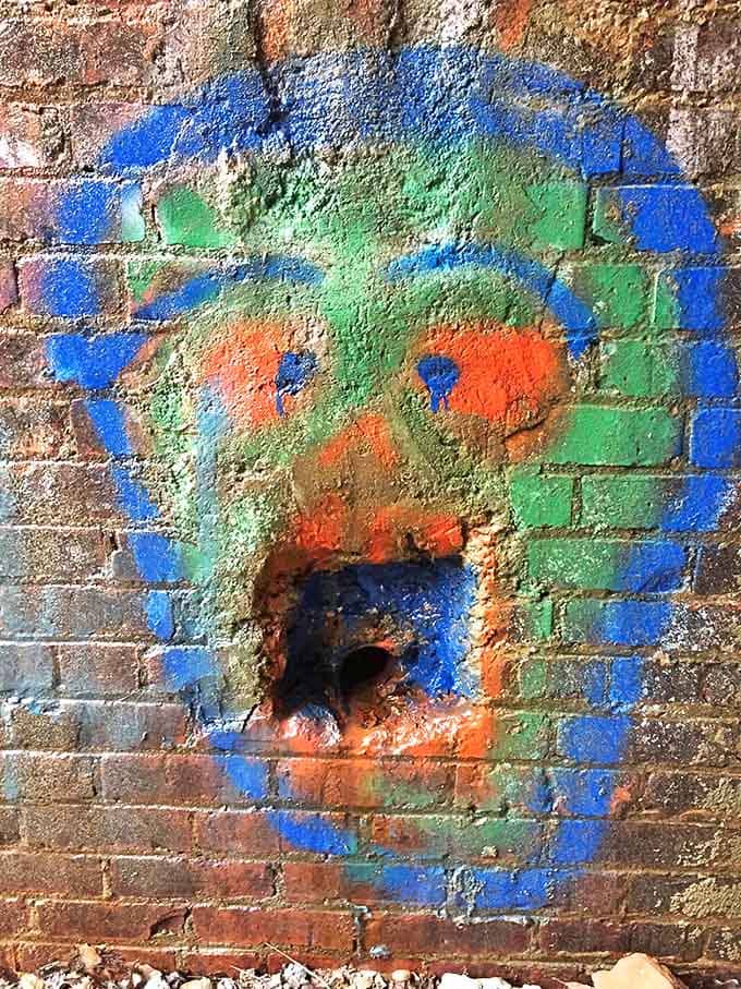 Colorful street art transforms the tunnel's industrial brick into something between whimsical and slightly unsettling.