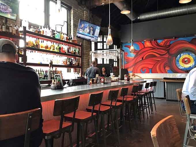The bar area beckons with colorful artwork and enough bottles to make any cocktail dream come true, staffed by bartenders who actually know their craft.