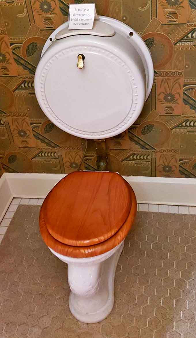 The pull-chain toilet and vintage fixtures transform necessary functions into historical experiences &ndash; bathroom technology that required genuine user commitment.