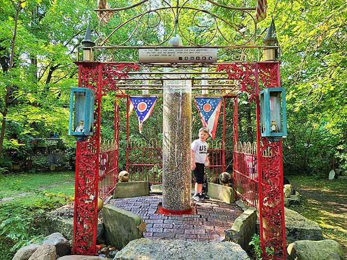 A red archway frames an ancient tree, creating a portal that blends Eastern aesthetics with Midwestern sensibility in the most unexpected backyard setting.