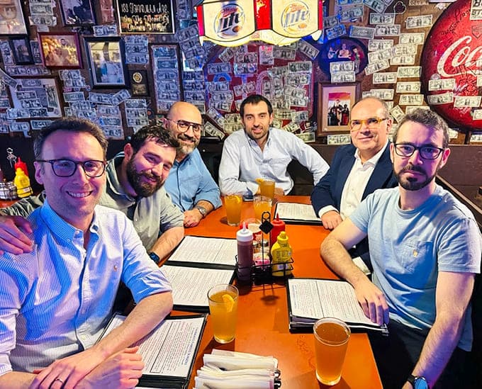 Happy diners gathered around orange tables, united in their appreciation for food that doesn't apologize for being generous and delicious.