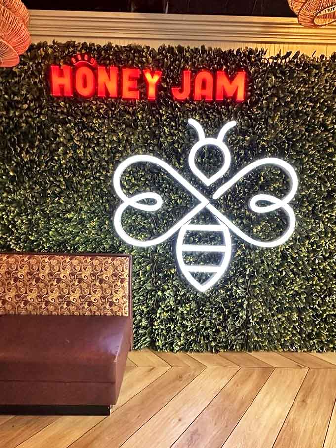 Wall decor: The neon bee glows against verdant backdrop – not just a logo but a promise of sweetness awaiting hungry visitors.