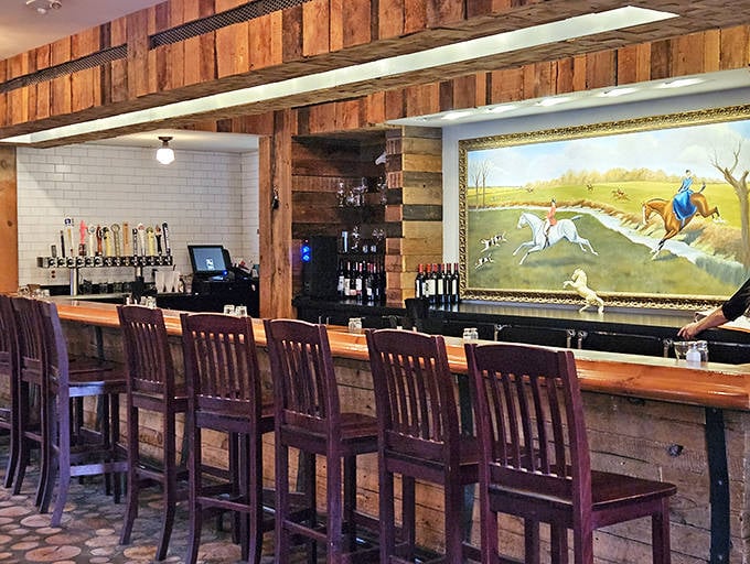 The bar area combines rustic charm with modern comfort, where equestrian artwork watches over patrons enjoying Michigan craft beers.