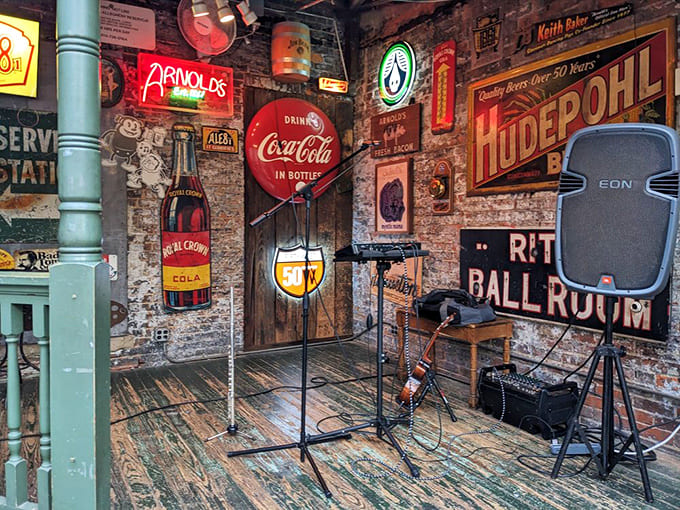Vintage signs and exposed brick create the perfect backdrop for live music, with the small stage ready to host local talent in this authentic setting.