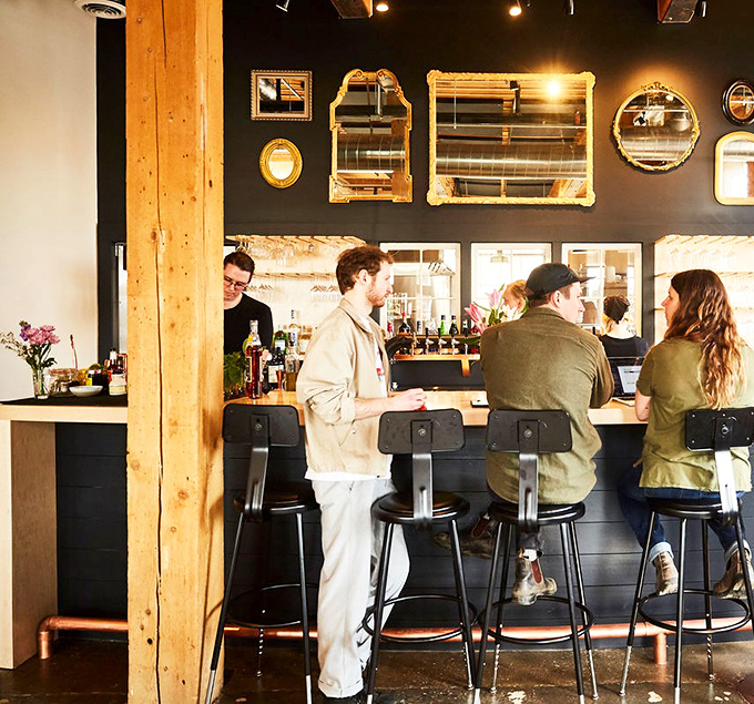 The bar wall's collection of mirrors reflects both drinks and good times &ndash; mixology meets gallery in the best possible way.