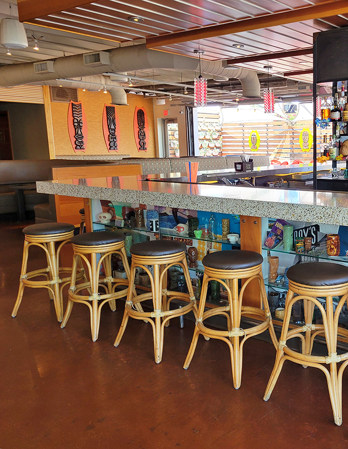 The bar at Hula's stands ready for rum-based adventures, with bamboo accents and tiki d&eacute;cor creating the perfect backdrop for tropical libations.