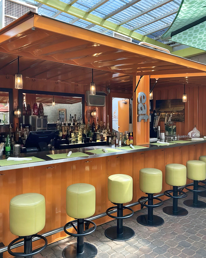 The sleek bar area invites solo diners and couples to perch on lime-green stools while sipping craft cocktails or freshly brewed coffee.