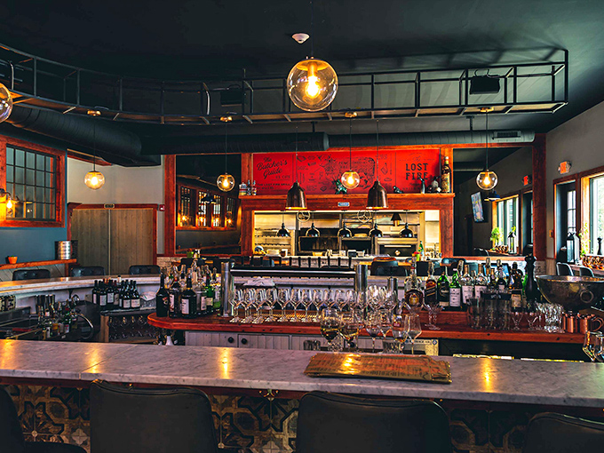 The bar area gleams with amber lighting and polished surfaces, promising expertly crafted cocktails to complement your meal.
