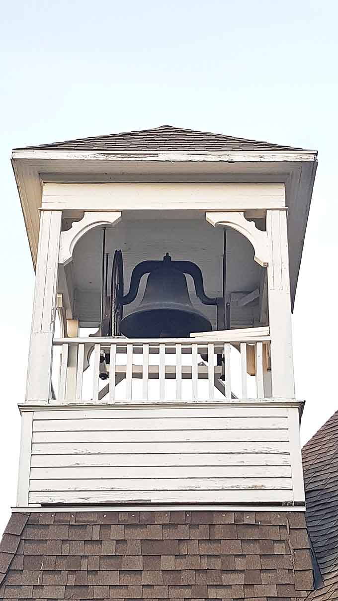 The church bell tower reaches skyward, ready to mark time, celebrations, and sorrows just as it has for generations.