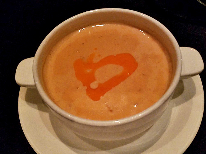 The crab bisque arrives with a heart-shaped drizzle of chili oil, its velvety texture and rich flavor making you wonder if you should have ordered a bowl instead of a cup.
