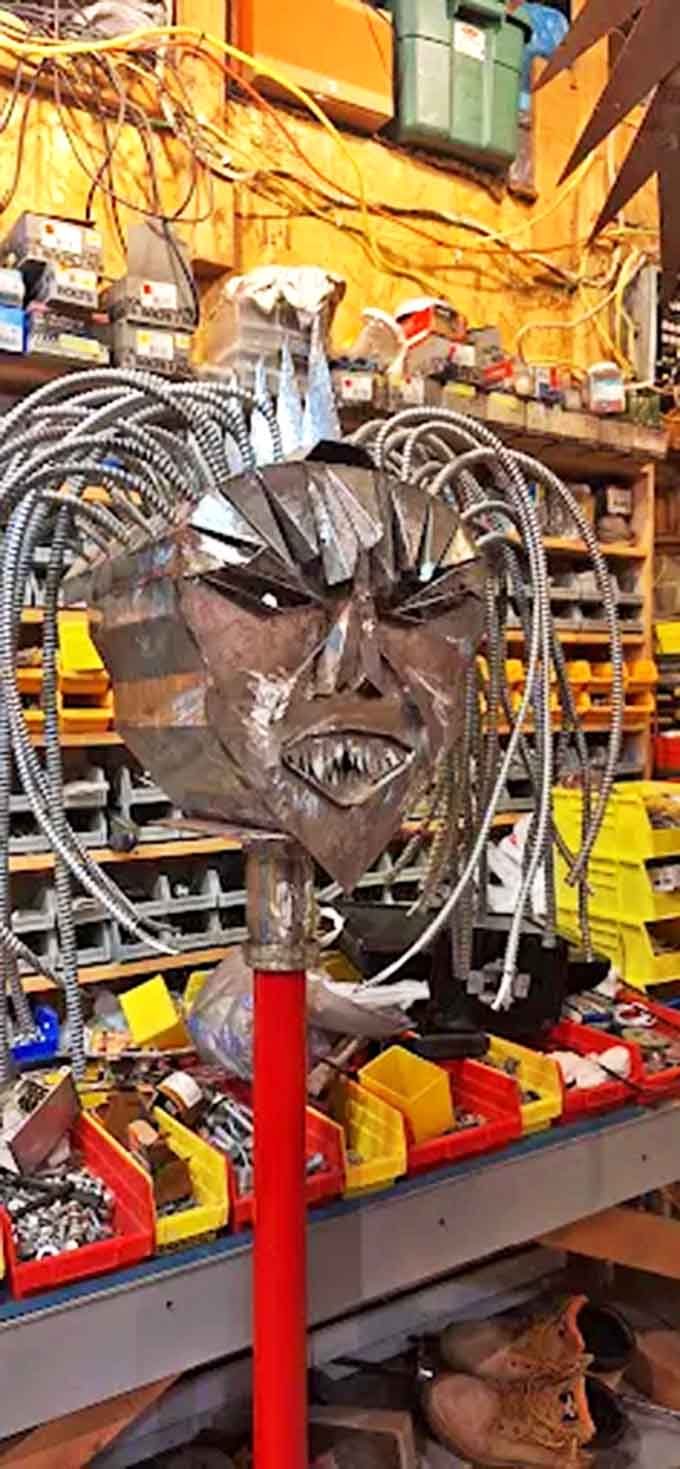 This haunting metal mask showcases the artist's versatility, transforming industrial scraps into an expressive face with surprising emotional impact.