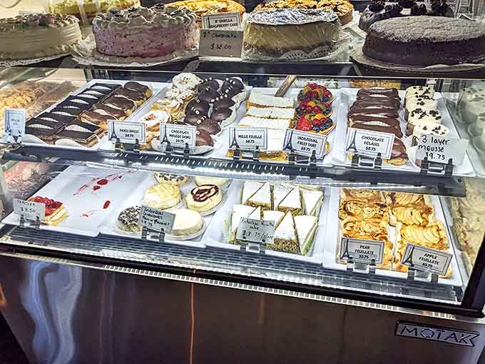 Sweet temptations beckon from behind glass &ndash; fruit tarts, chocolate eclairs, and macarons arranged like edible jewels in a treasure chest.