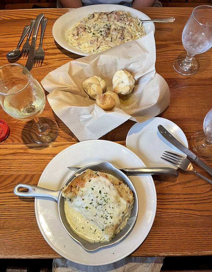 A table set for a proper Italian feast &ndash; pasta, garlic knots, and wine create the perfect trifecta for a memorable meal.