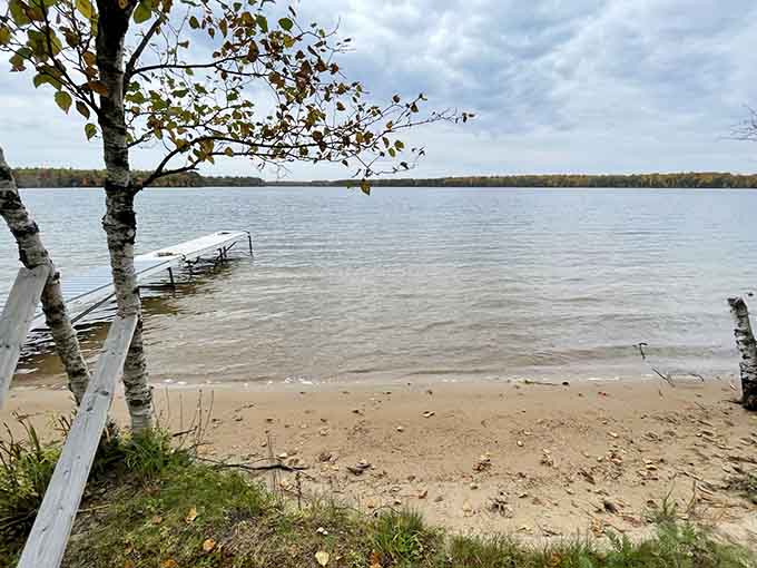 A weathered dock stretches toward autumn waters, inviting contemplation and perhaps one last swim before winter.