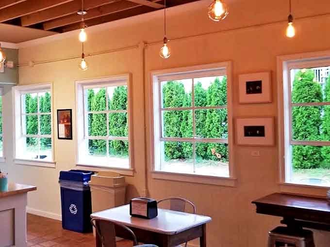 Natural light floods through windows framing lush greenery &ndash; the perfect backdrop for savoring your coffee and pastry moment.